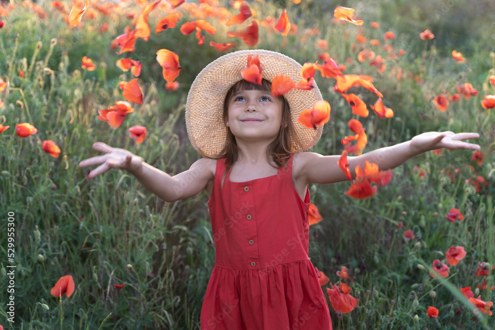 Cute kid at poppy field tosses petals flowers. Beautiful little girl in ...