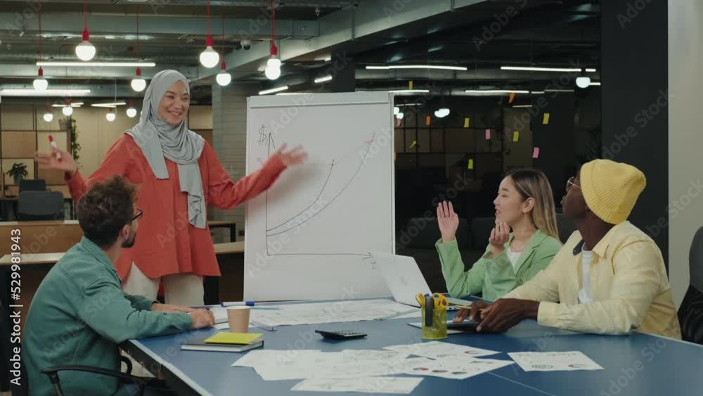 Muslim woman leader thanking her colleagues using flipchart.Different ...