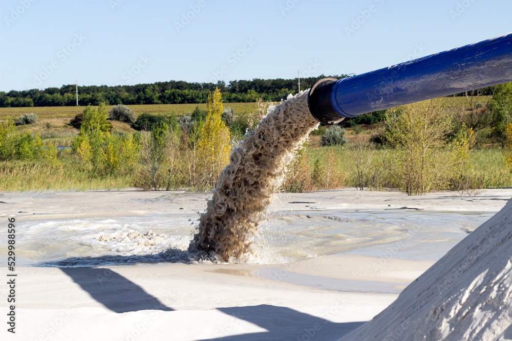 dirty water is poured from an industrial pipe into the environment ...