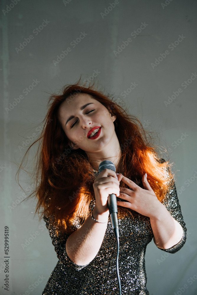 Portrait of redhead female singer woman in sparkly evening dress ...