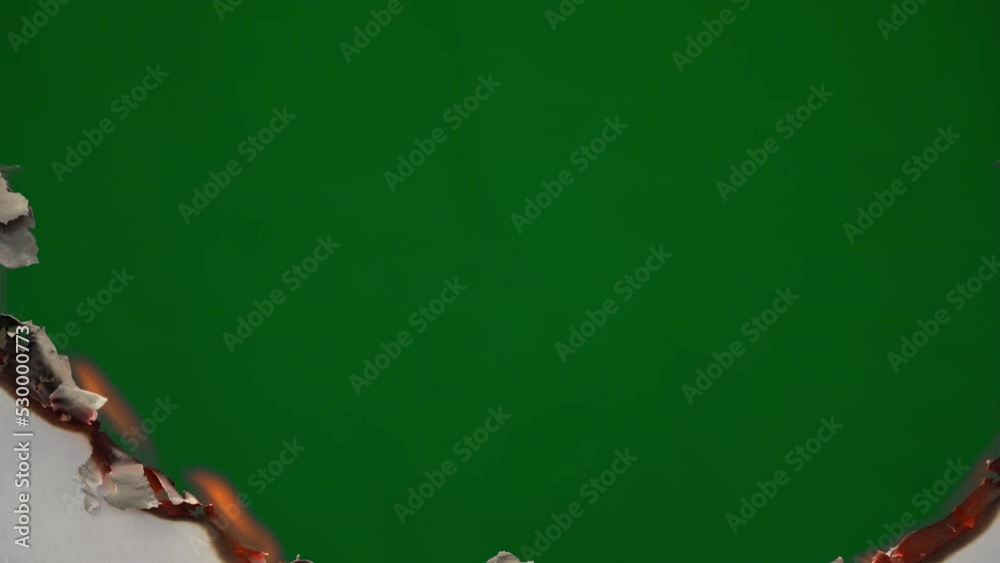 White paper burns from below on a green background copy space. The ...