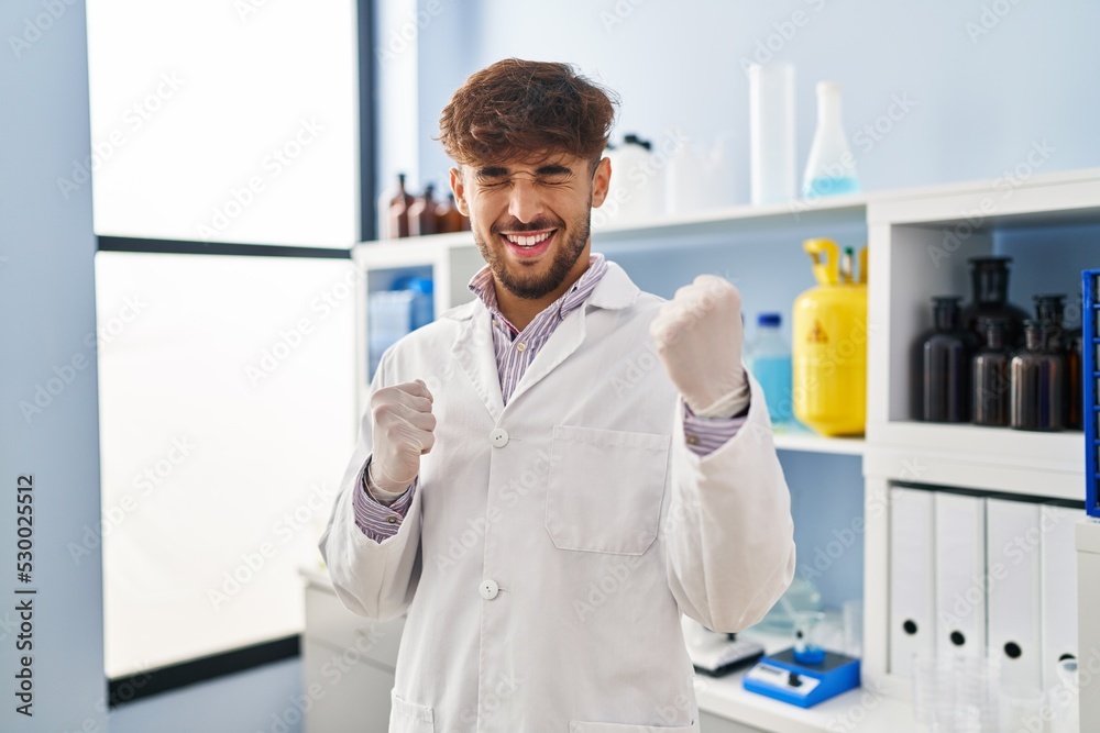 Arab man with beard working at scientist laboratory celebrating ...