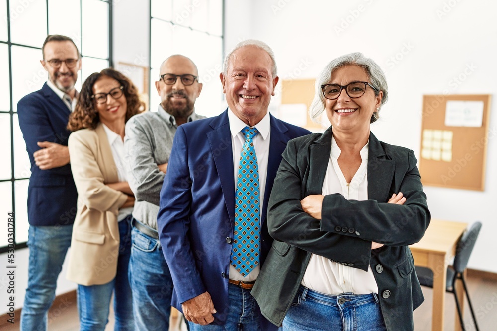 Group of middle age business workers smiling happy standing with arms ...
