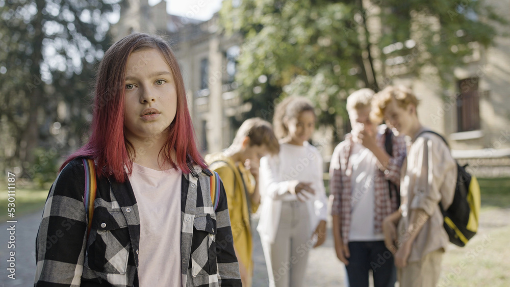 Group of school children bullying sad unpopular girl for distinctive ...