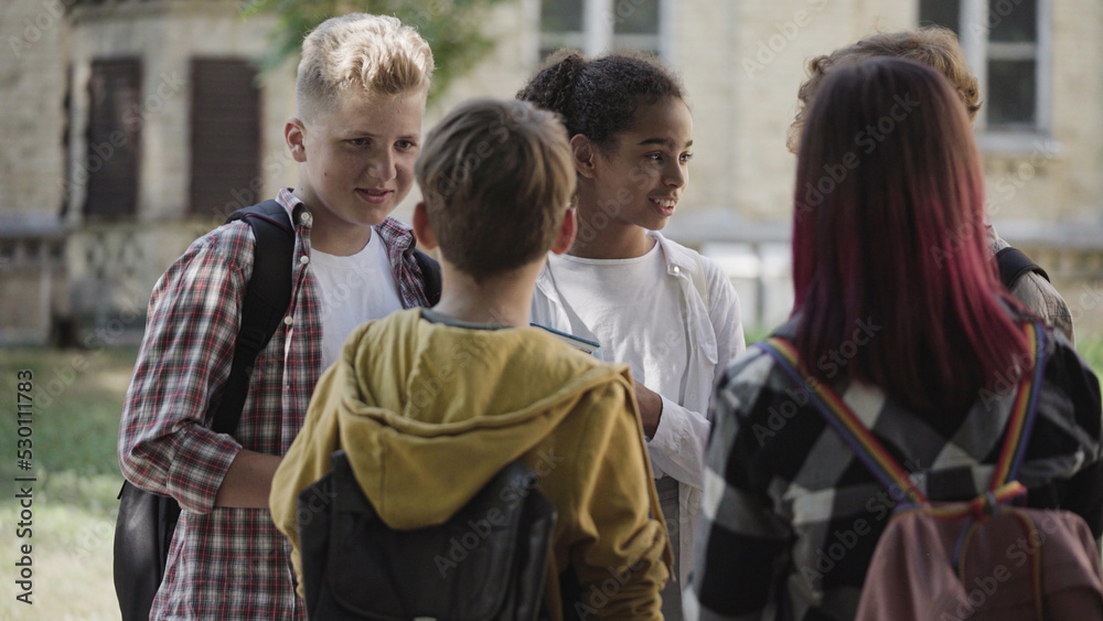 Happy school children talking and laughing, having fun together after ...