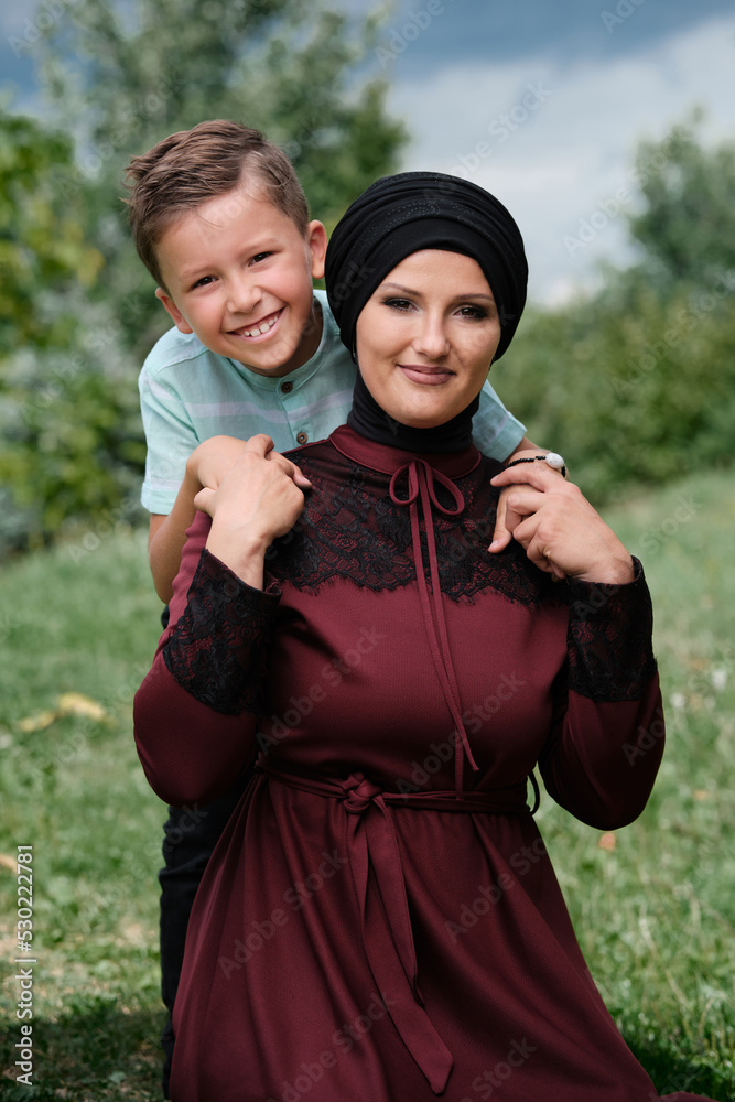 Portrait of a happy young Muslim family in the summer park mother in ...