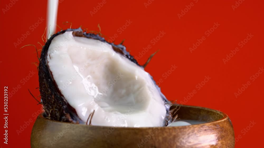 Coconut milk pouring, dripping coconut water, drops of coconuts oil ...