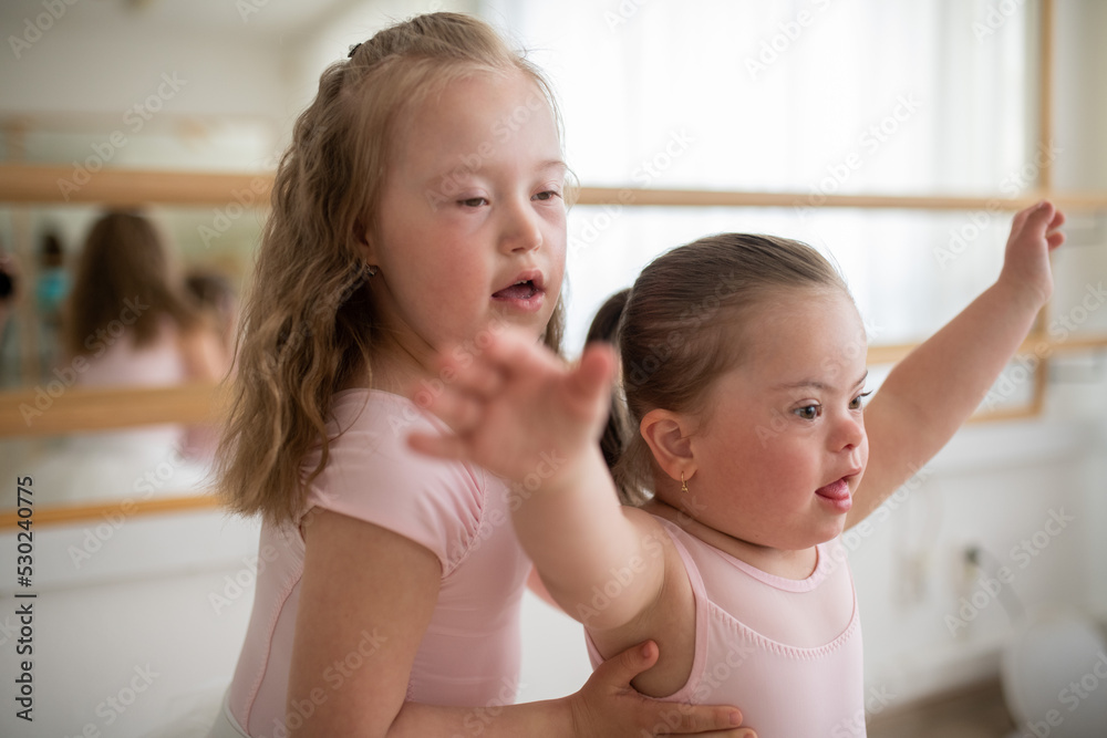 Little sisters with down syndrome dancing ballet in ballet school ...