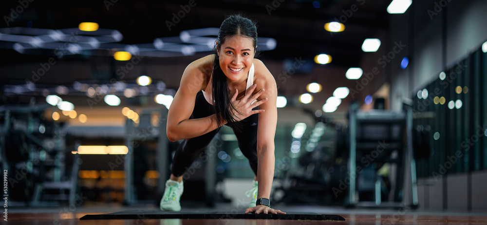 Happy beautiful young asian woman doing push ups exercise with one hand ...