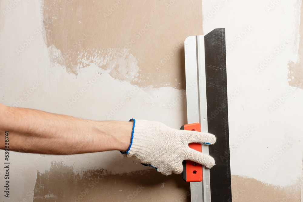Professional plaster walls. Builder with plastering tools apartment ...