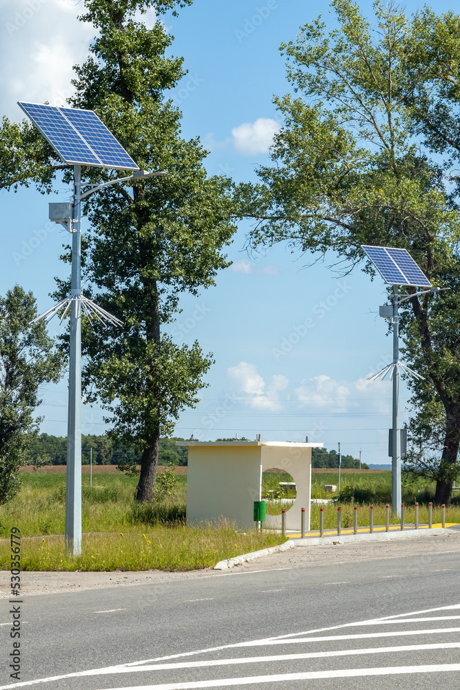Lamp post with solar panel system on road with blue sky and trees ...