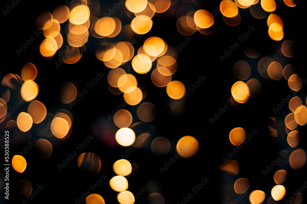 Yellow abstract bokeh made from Christmas lights on black isolated background. Holiday concept ...