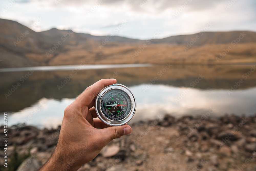 man holding compass on lake background Stock Photo | Adobe Stock