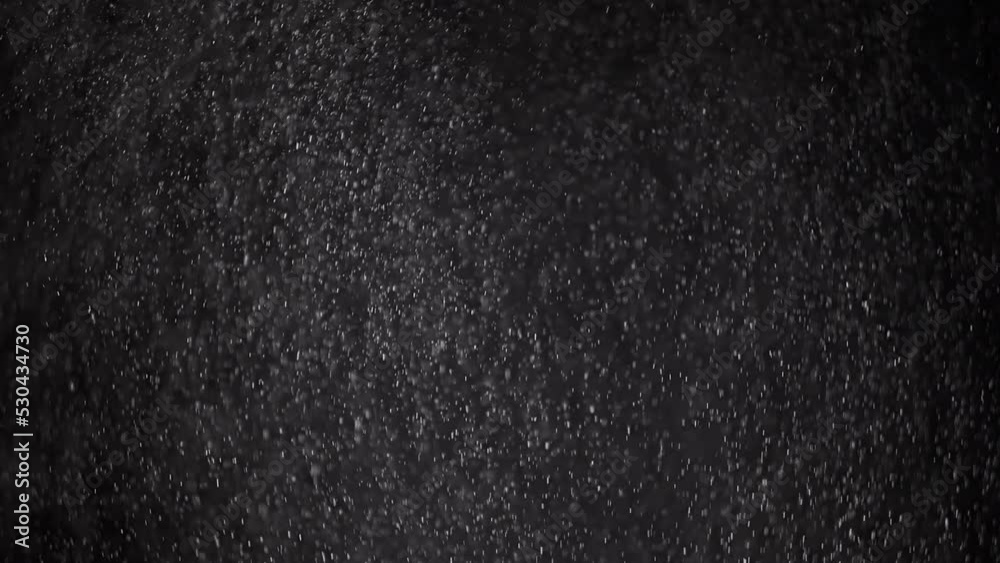 Stream of falling mixed particles of dust, debris, powder on black ...