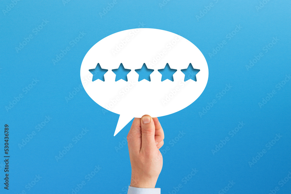 The best rating. Hand holding five star shape in speech bubble on blue ...