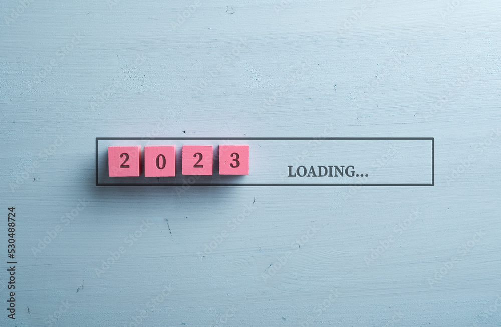 2023 Loading sign spelled over pink wooden blocks and blue wooden ...
