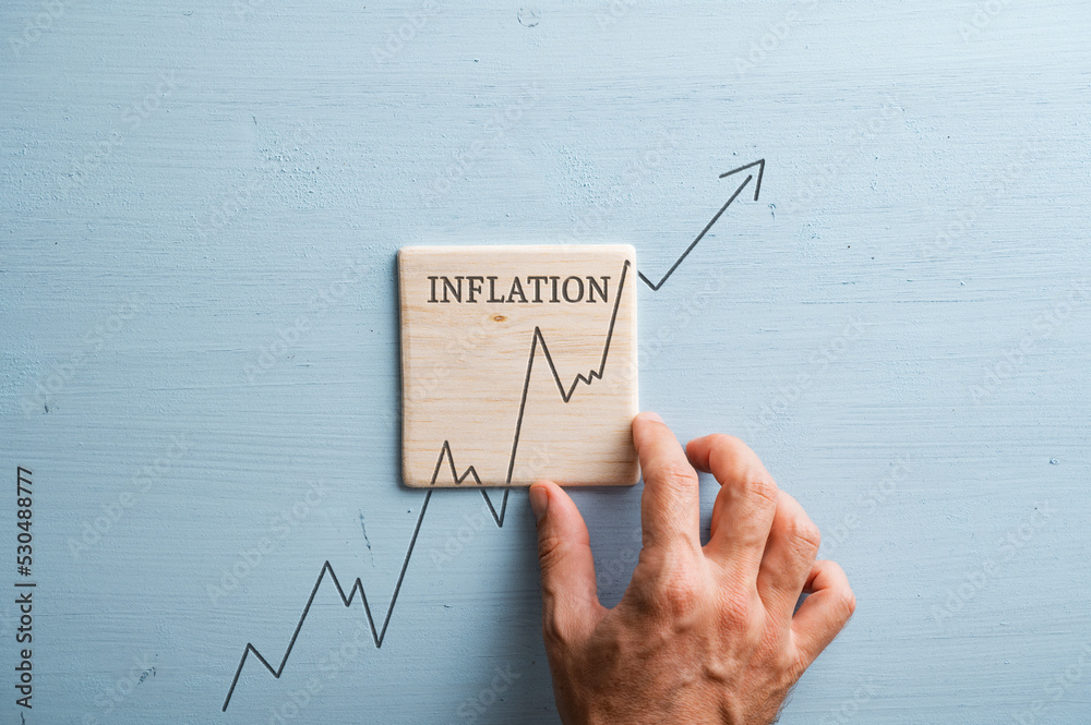 Word Inflation cut into wooden tile with a rising graph drawn right ...