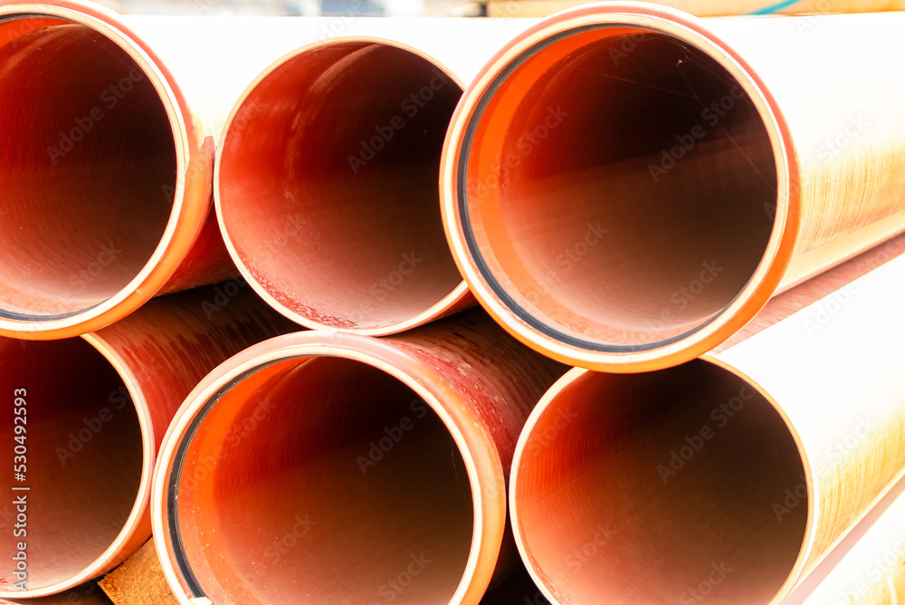 Orange sewer pipes at the construction site. Preparation for the ...