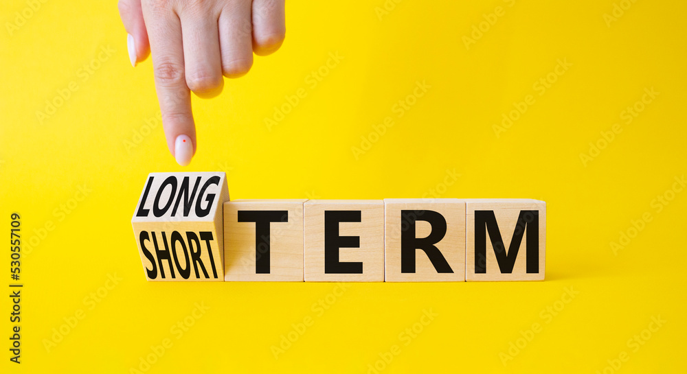 Long term vs Short Term symbol. Businessman hand points at Turned ...
