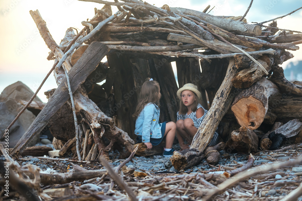 two little cheerful girls sisters of different ages are sitting in a ...