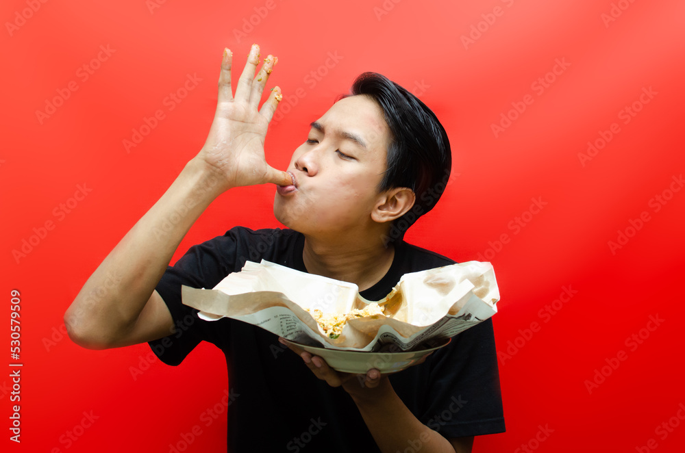 An Indonesian man eats rendang using bare hands without spoon and fork ...