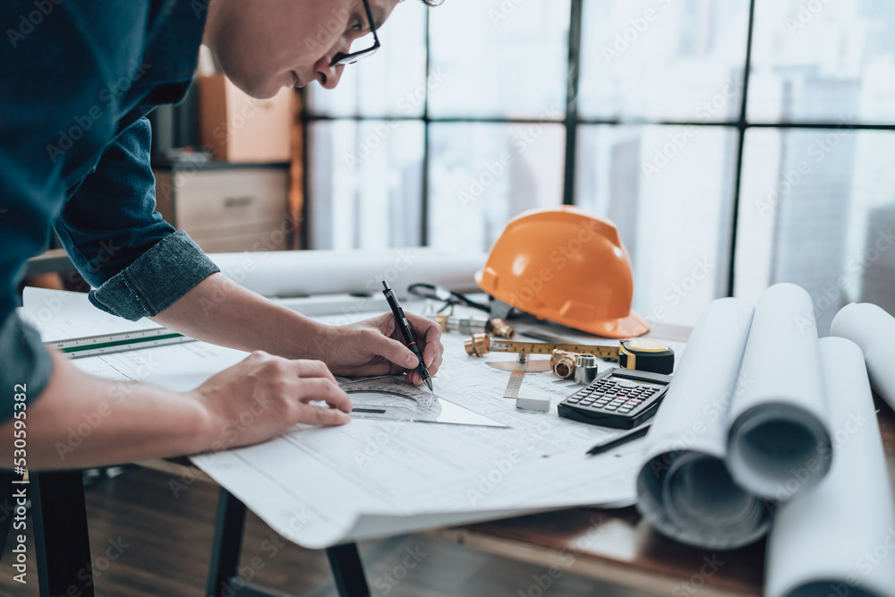 Engineering working with drawings inspection and writing on the office ...