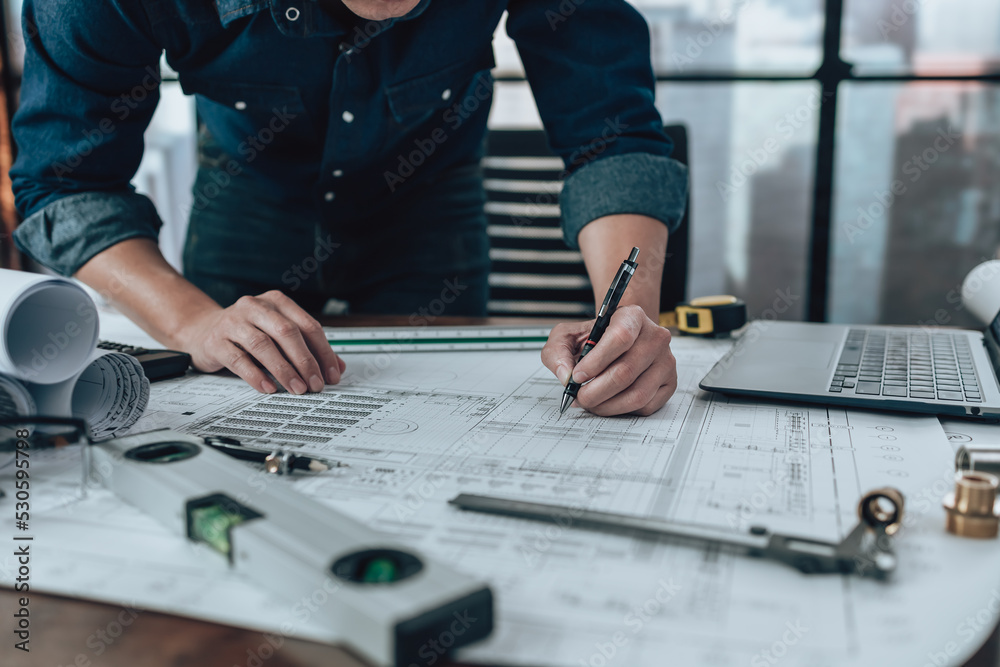 Engineering working with drawings inspection and writing on the office ...