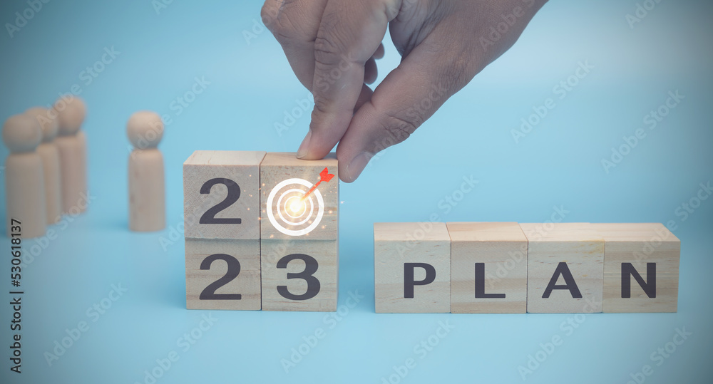 2023 and PLAN on wooden cubes on blue background. 2023 setting plan for ...