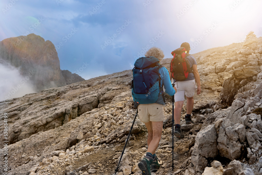 hiking couple walk with backpack in the mountains under the sun ...
