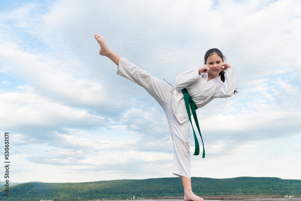 teen girl practicing karate. teen child fighter on sky background. teen ...