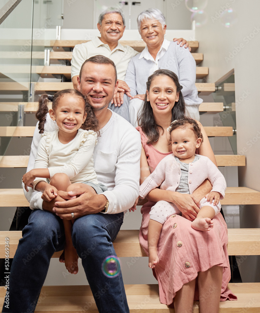 Portrait of a happy family posing for a picture on stairs in a house ...