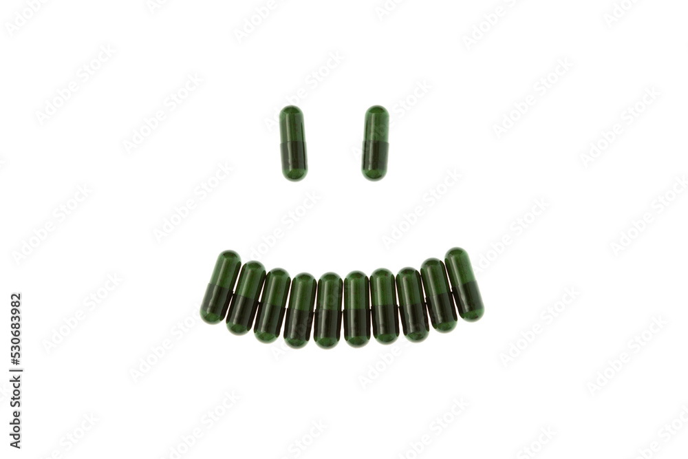 Antidepressants. Green Herb capsules with plant extract in shape smile ...