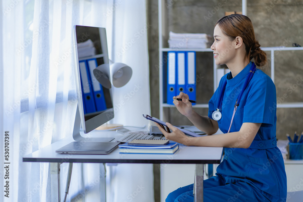 Foto de Smiling cute Asian female nurse wearing blue clothes and ...