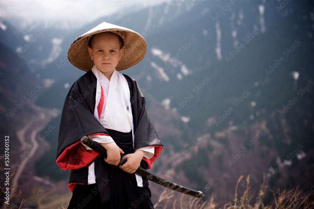 A young caucasian boy seven year old dressed as Samurai in black and ...