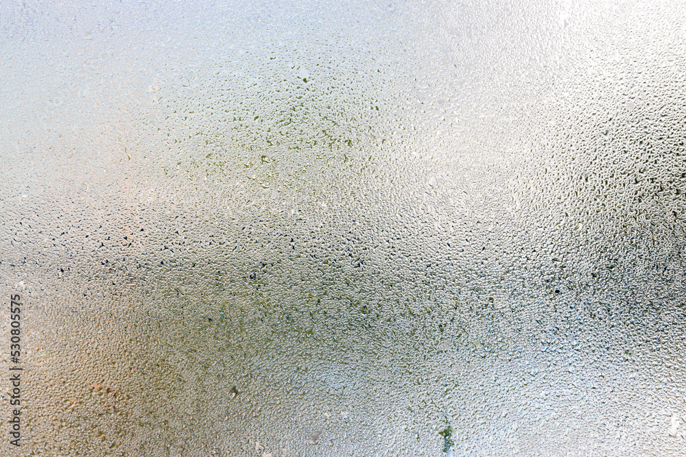 Misted glass, silver rain drops dew drops on transparent glass window ...