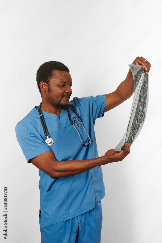 Black surgeon doctor bearded man in blue coat with stethoscope holds X ...
