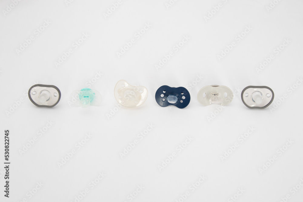 Six different baby pacifiers on a white background. Different types of ...