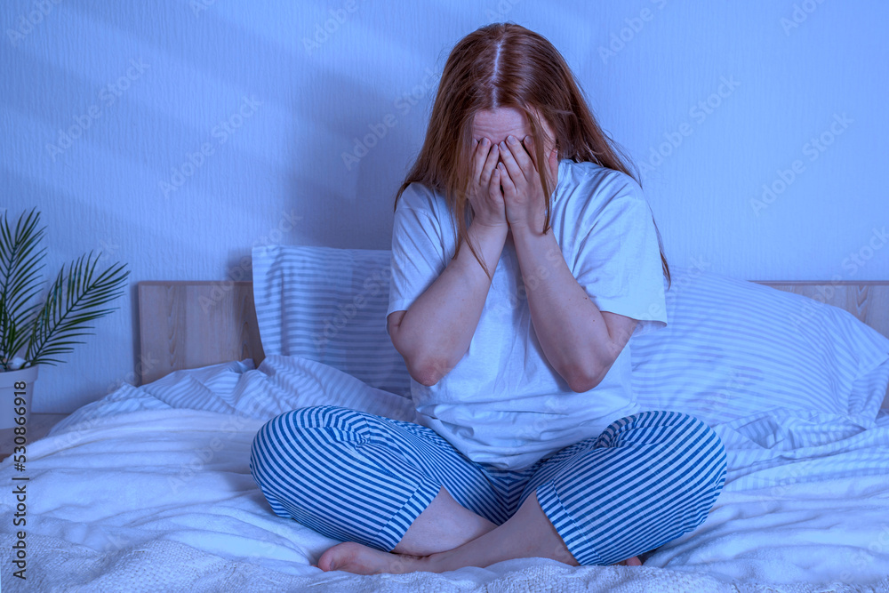 Woman sad crying in bed at home in the morning. Lady with long hair in ...