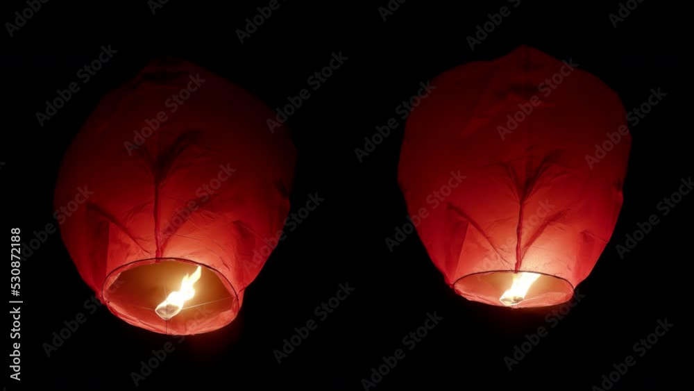Two big fire paper lanterns floating in the night sky. Seamlessly ...