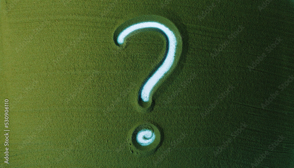 Hand drawing Question Mark Symbol in the Green Sand. Male hand writes a ...