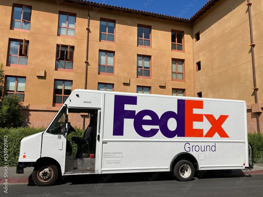 FedEx Ground delivery truck parked at residential building. Side view ...