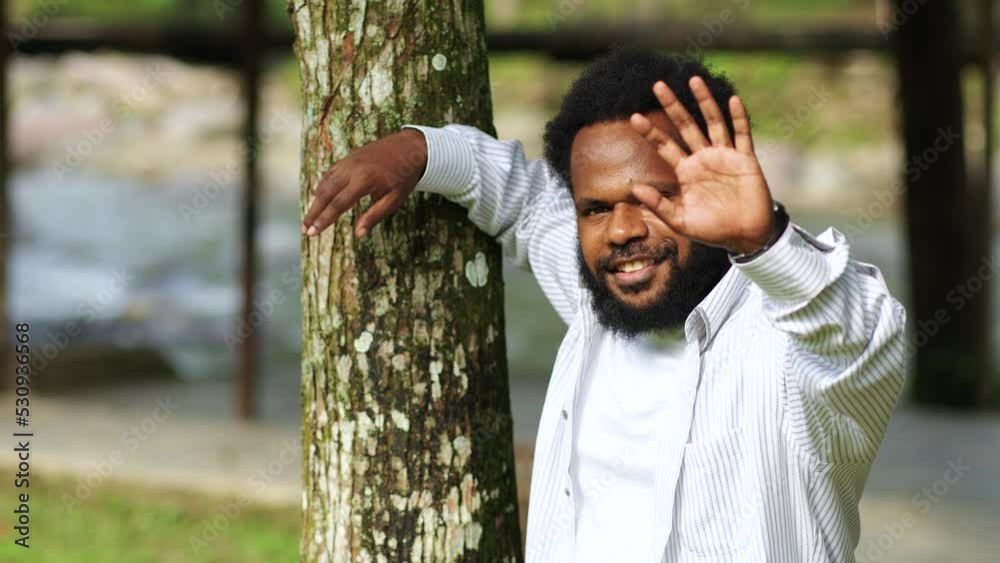 A Man Waving His Hand Happily While Leaning to a Tree Stock ビデオ | Adobe ...