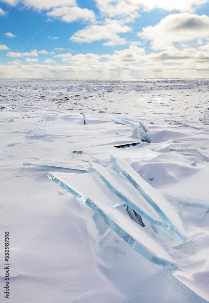 Snow-covered ice hummocks with fragments of blue ice on the frozen ...