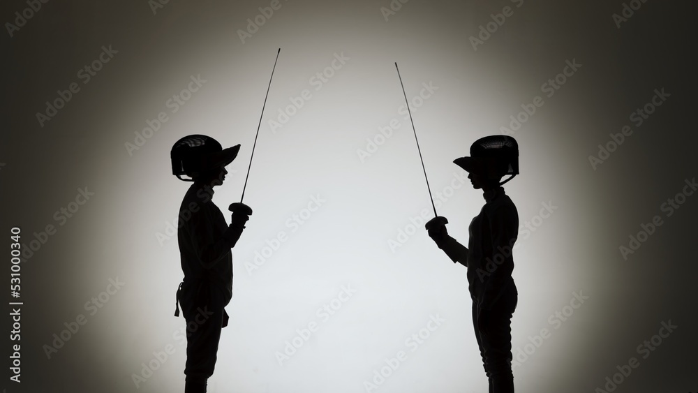 Side view of black silhouettes two young female swordswoman saluting ...
