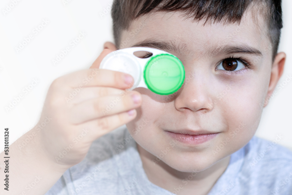 cute adorable smiling kid holding in front of one eye a contact lens ...