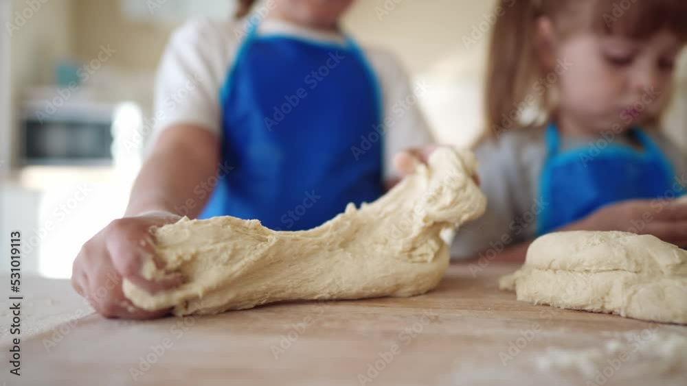 children making dough in the kitchen. two little girls cook in the ...