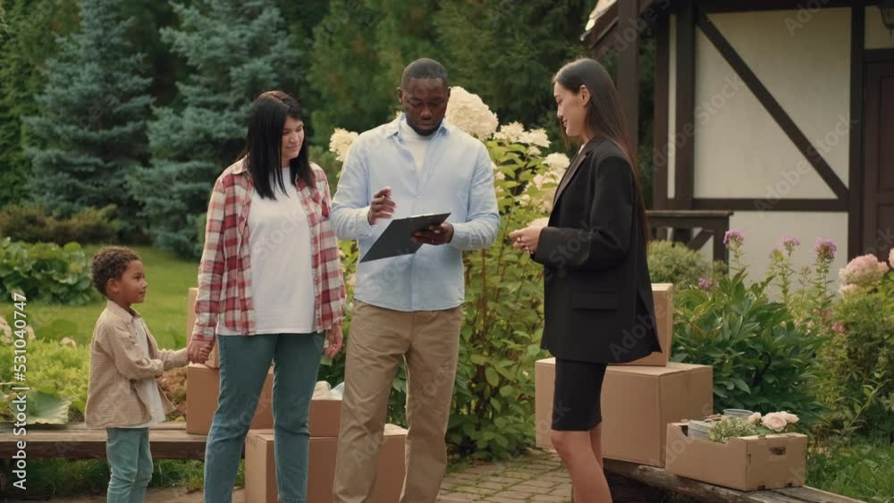 Asian female real estate agent selling a house to a multi-ethnic family ...