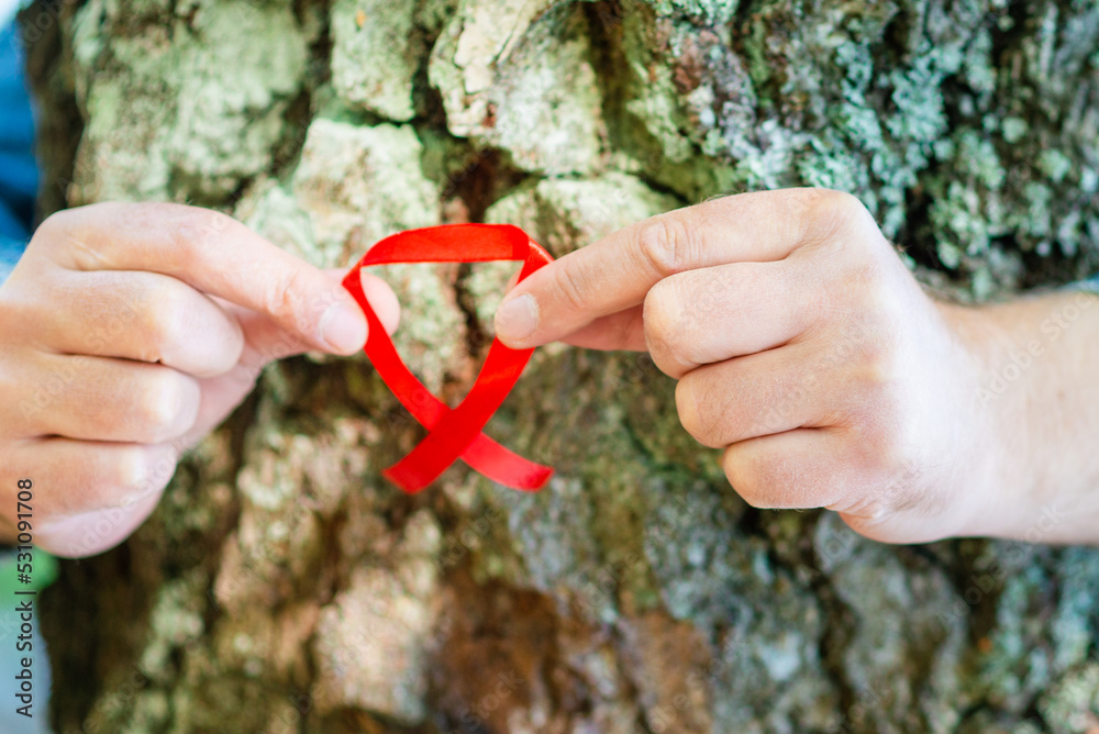 Young man with a red awareness ribbon for the fight against AIDS in his ...