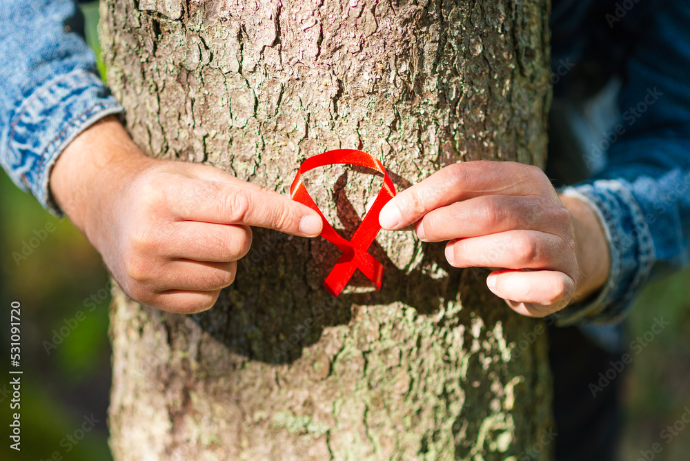 Young man with a red awareness ribbon for the fight against AIDS in his ...
