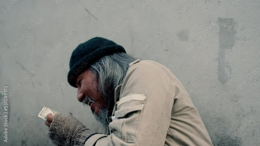4k, A homeless Asian old man accepts a banknote from a passerby and he ...